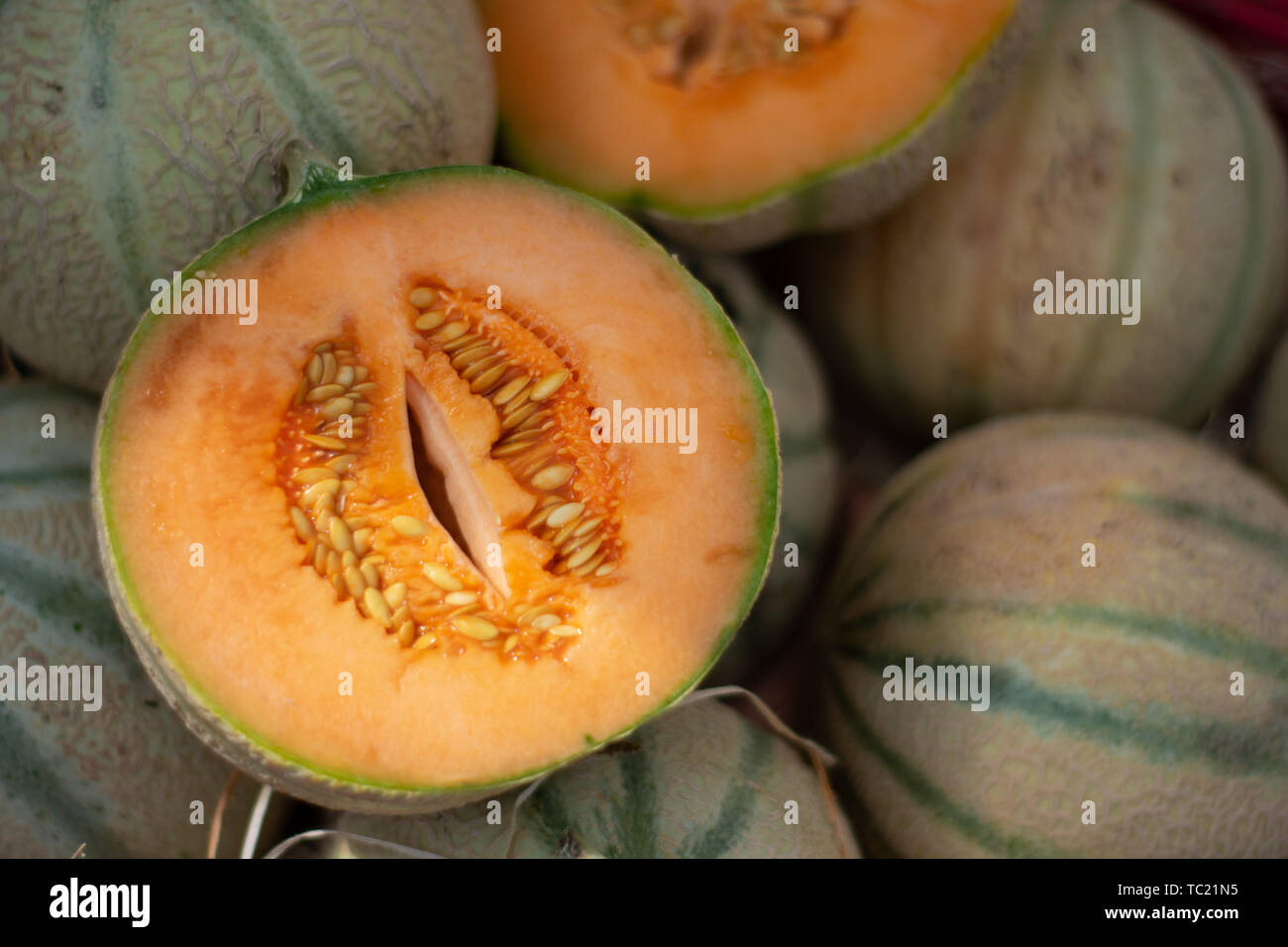 Open cut Charentais melon on market pile Stock Photo - Alamy