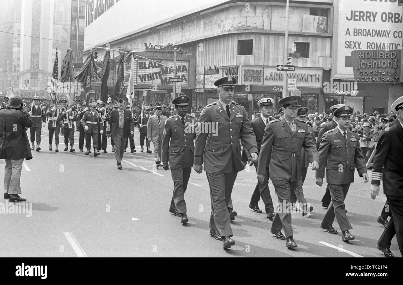 Uniformed and decorated officers march in the street, participating in ...