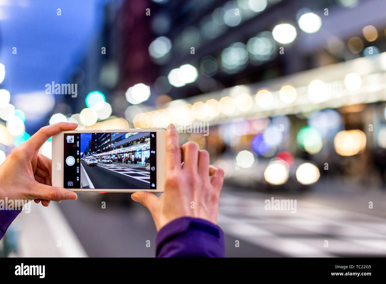 Hand and mobile phone on city road Stock Photo - Alamy