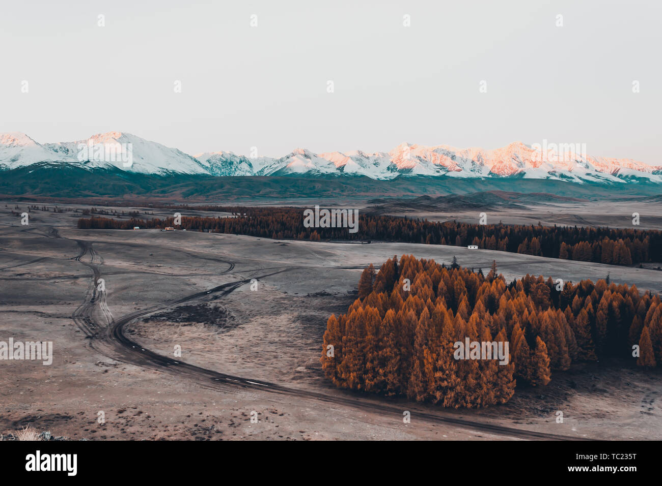 Soft hills in valley with mountain range on horizon. Roads lead to ...