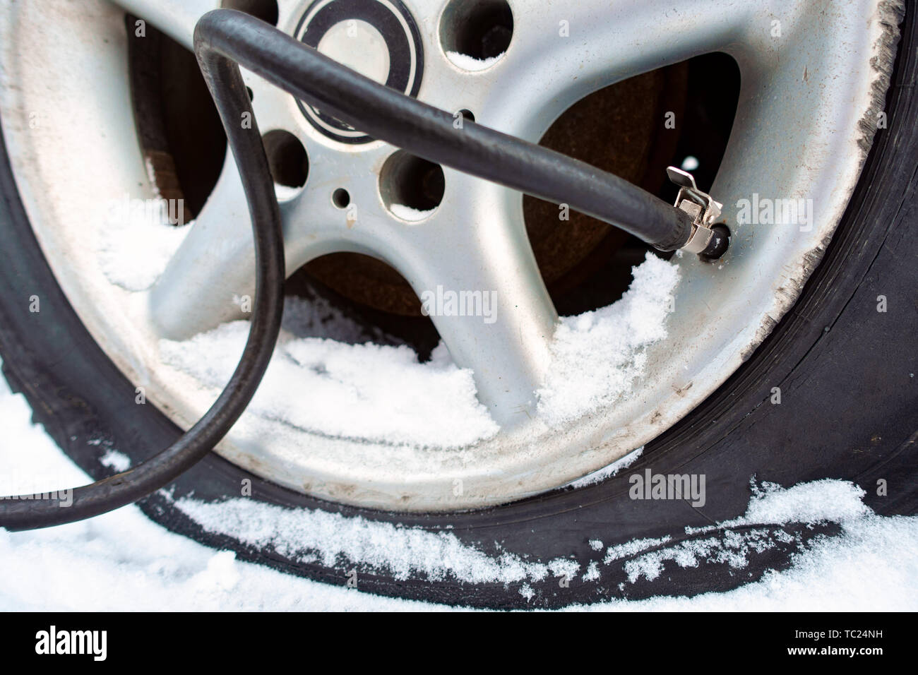 punched wheel cars. the pump pumps air into the tire in winter Stock ...