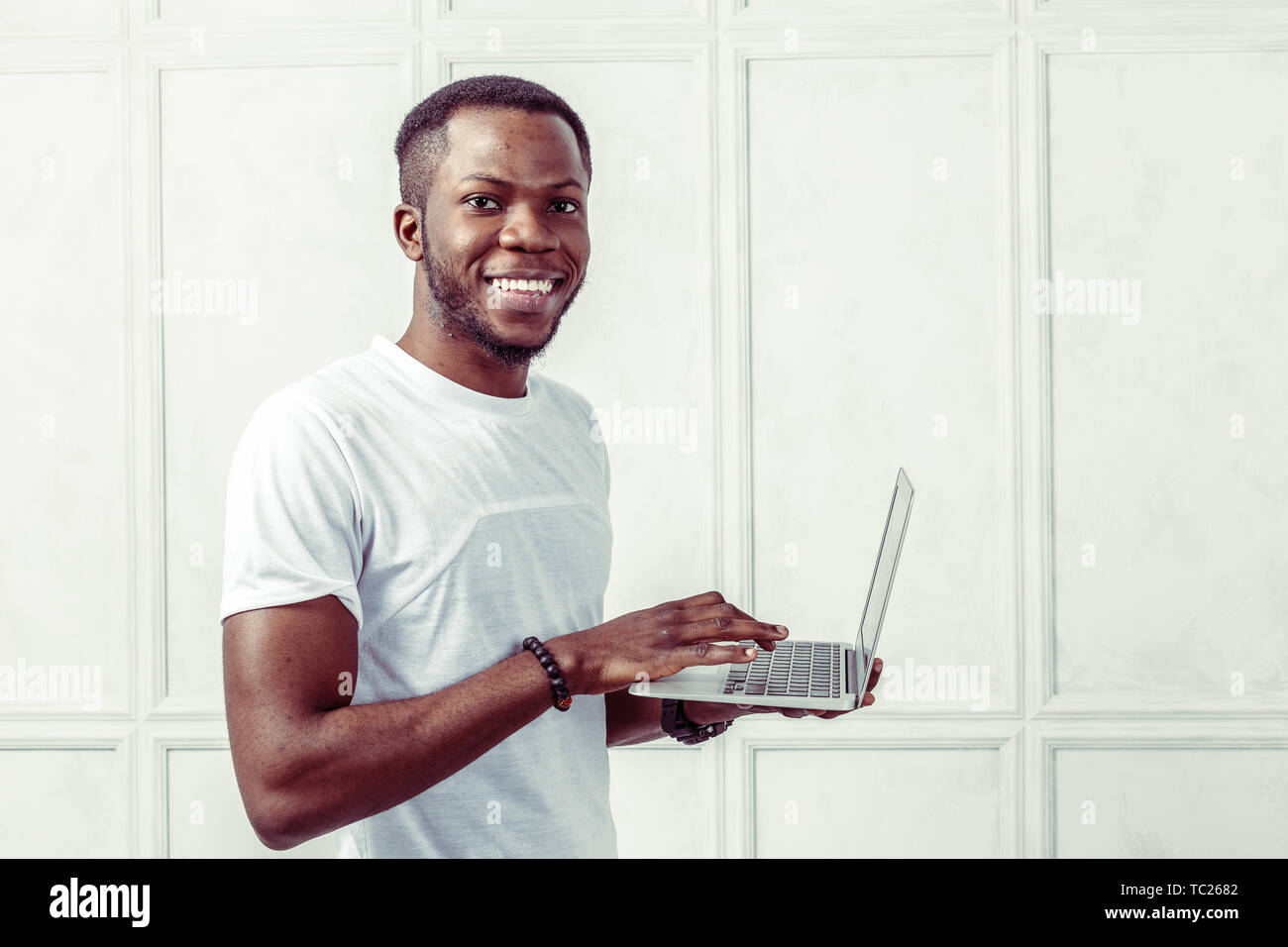 African young man holding laptop Stock Photo - Alamy