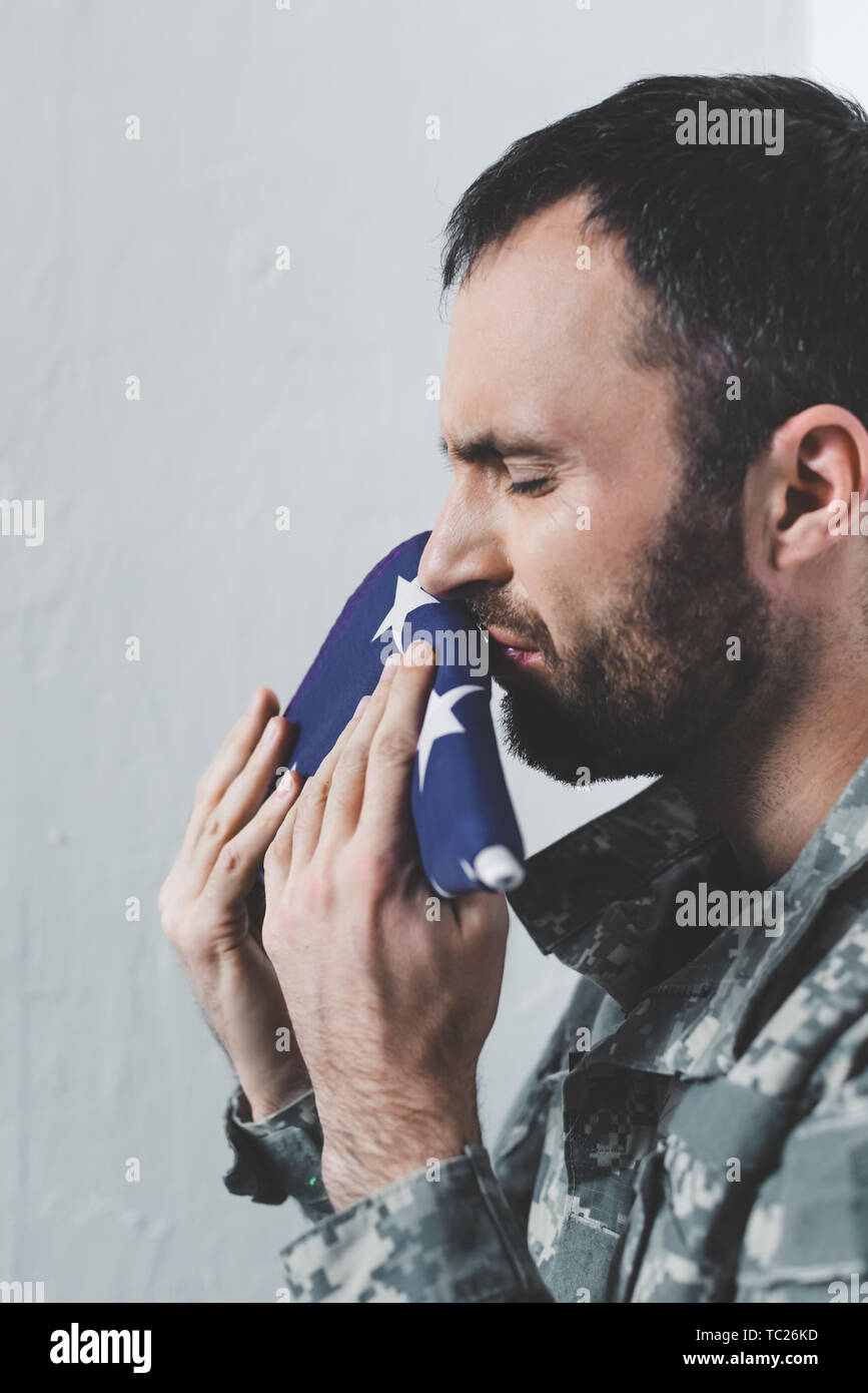 depressed bearded military man crying while kissing usa national flag ...