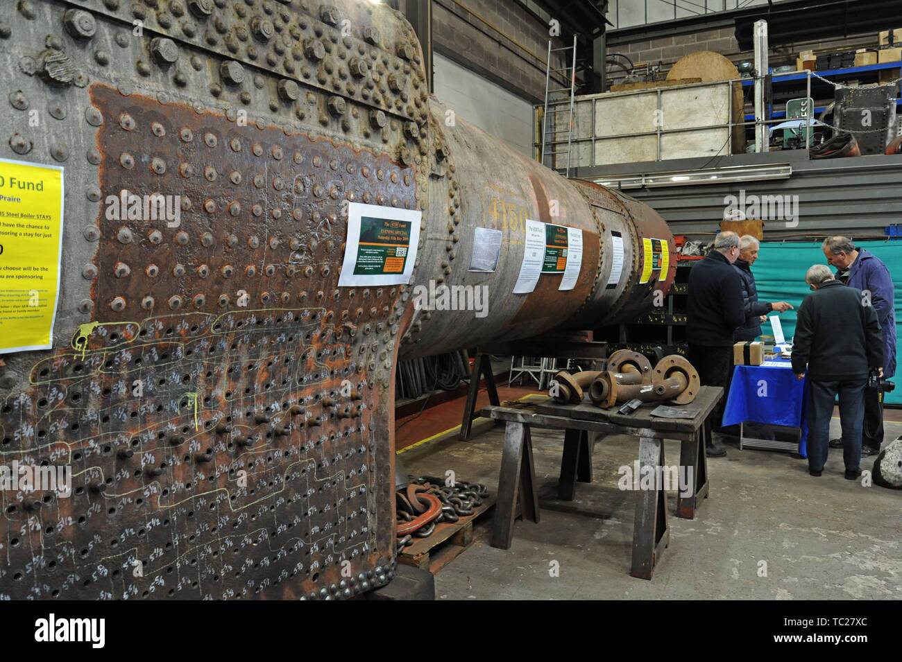 People examining steam locomotive boilers undergoing restoration at ...