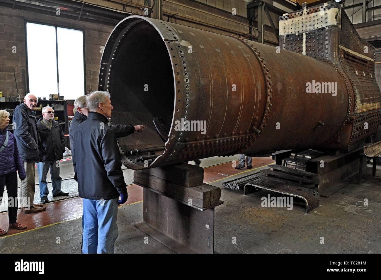 People examining steam locomotive boilers undergoing restoration at ...