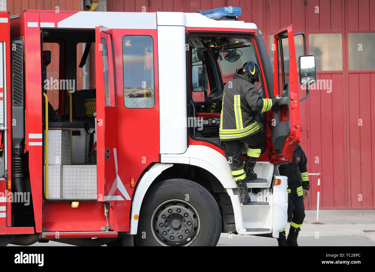 firefighter exits the truck running with the sirens on to extinguish ...