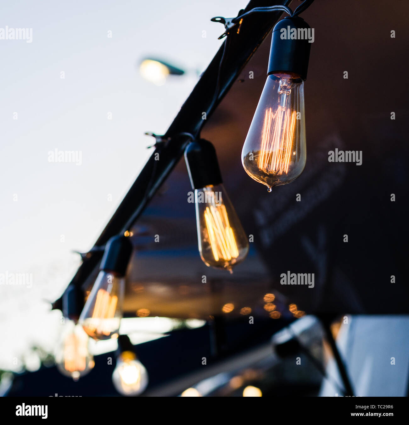 Hanging light bulbs at a street food market Stock Photo - Alamy