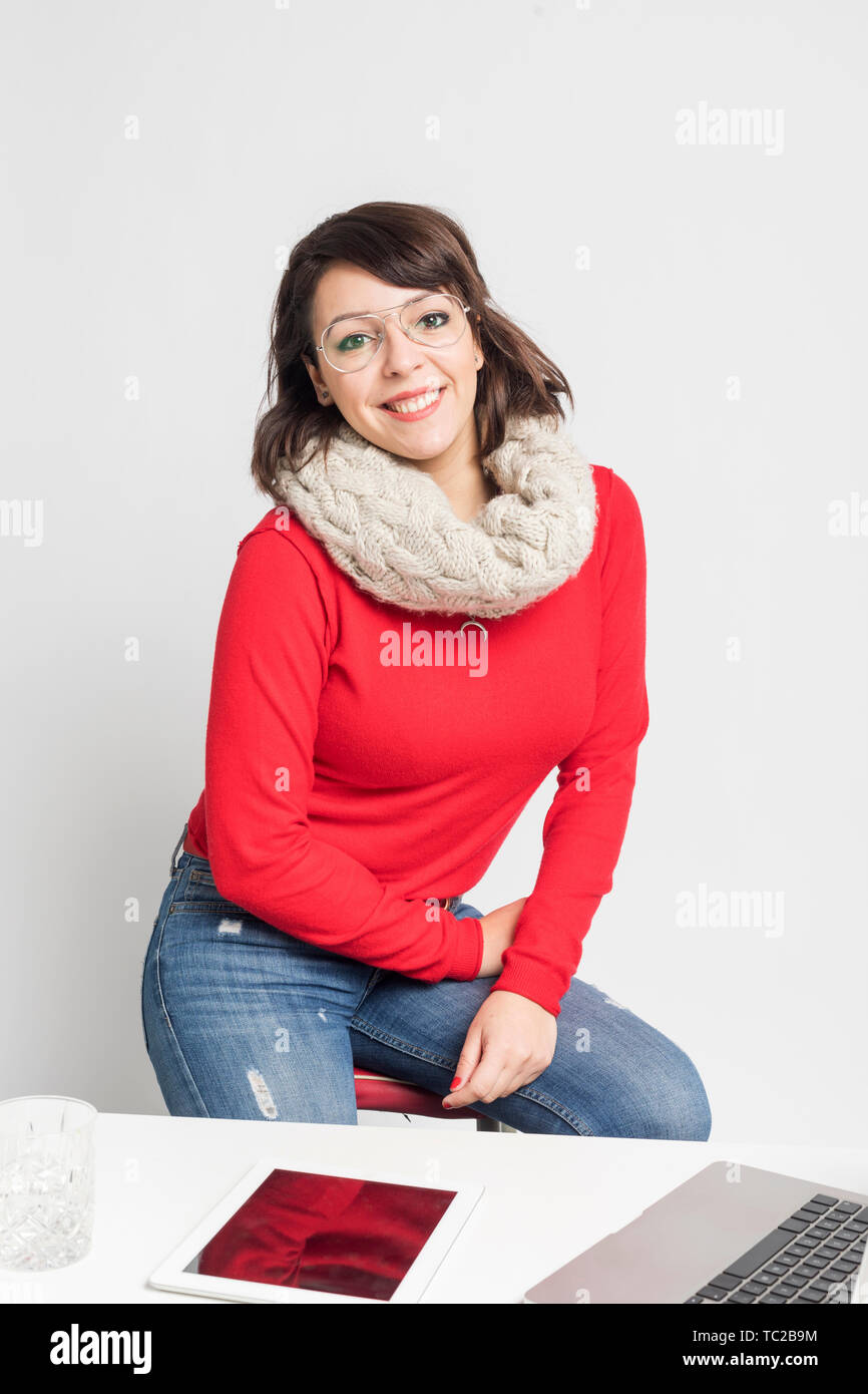 Front view of beautiful woman in casual wear sitting on a stool while ...