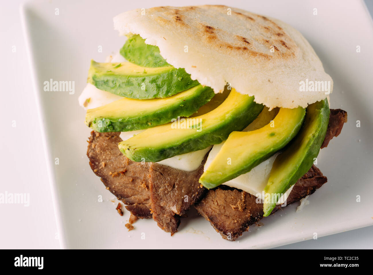 Arepa llanera, South American food on white plate Stock Photo - Alamy