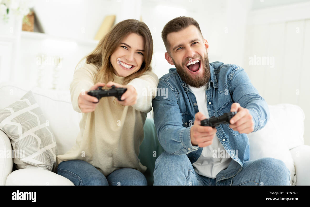 Laughing Couple Playing Video Games By Joysticks Stock Photo - Alamy
