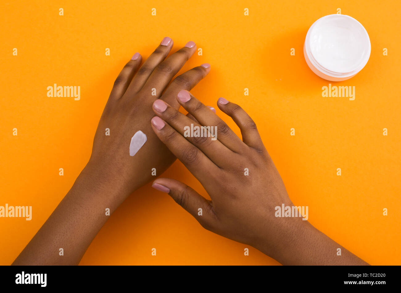African american woman applying cosmetic hand cream on skin Stock Photo ...