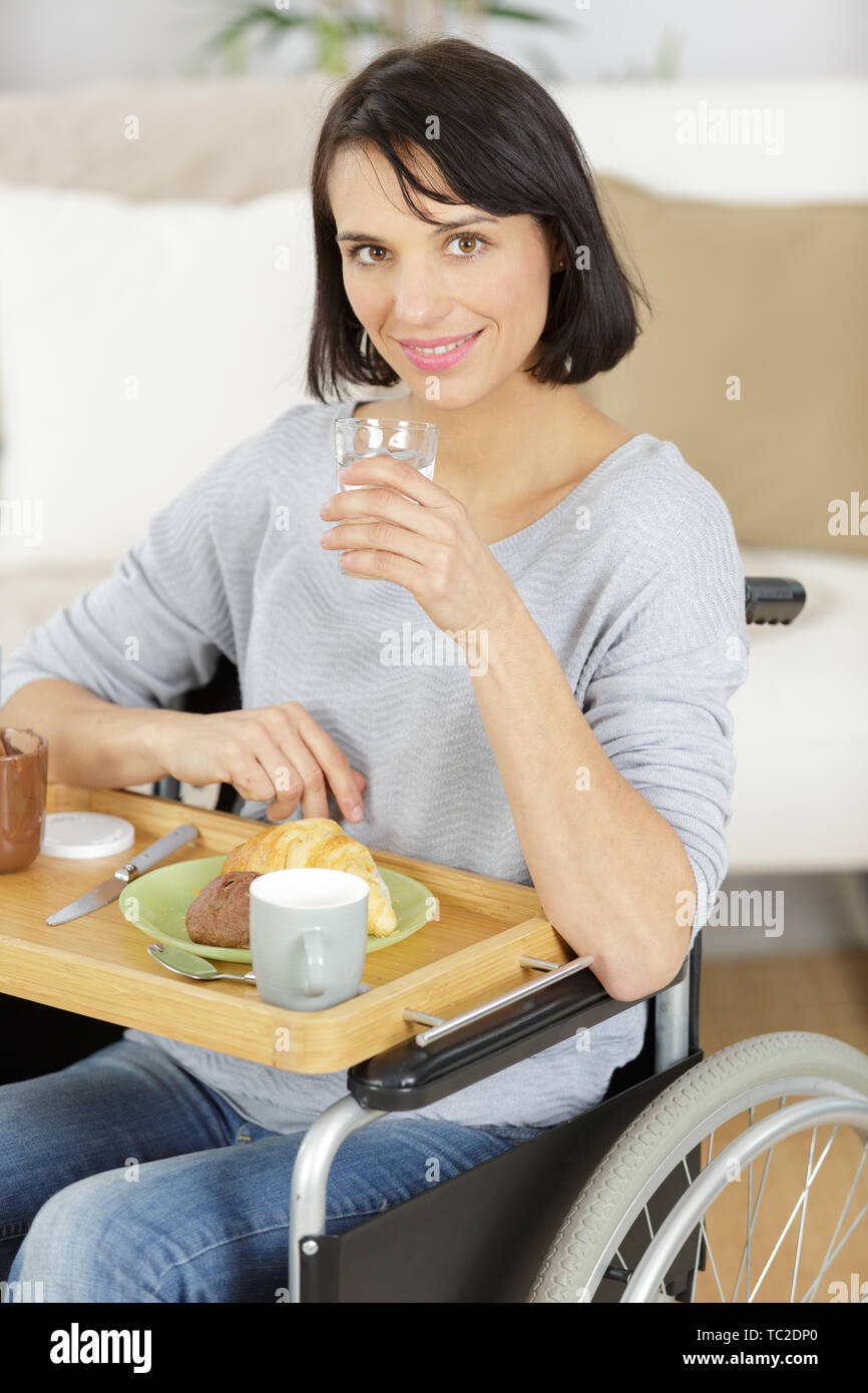 lady in wheelchair at home eating meal from a tray Stock Photo - Alamy
