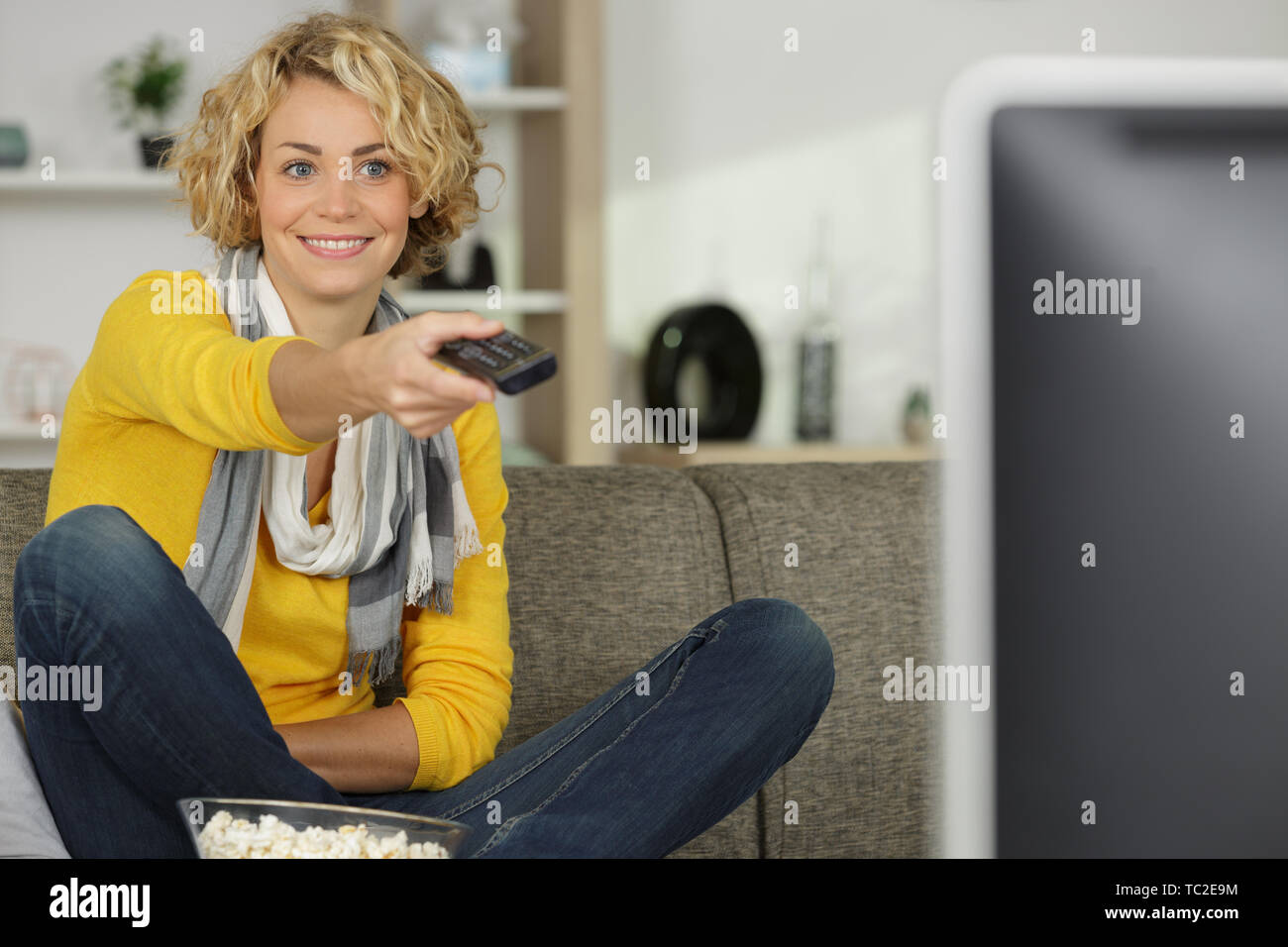 pretty young woman with remote control Stock Photo - Alamy