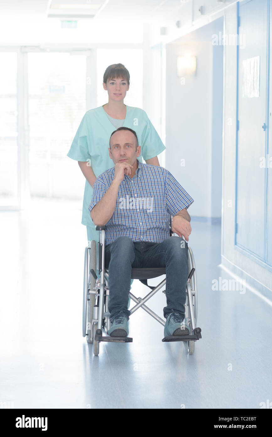 nurse pushing patient in wheelchair Stock Photo - Alamy