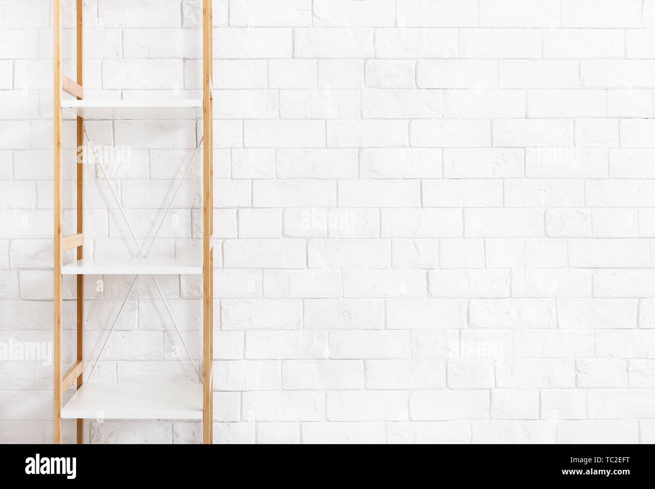 White wooden rack on white brick wall background Stock Photo - Alamy