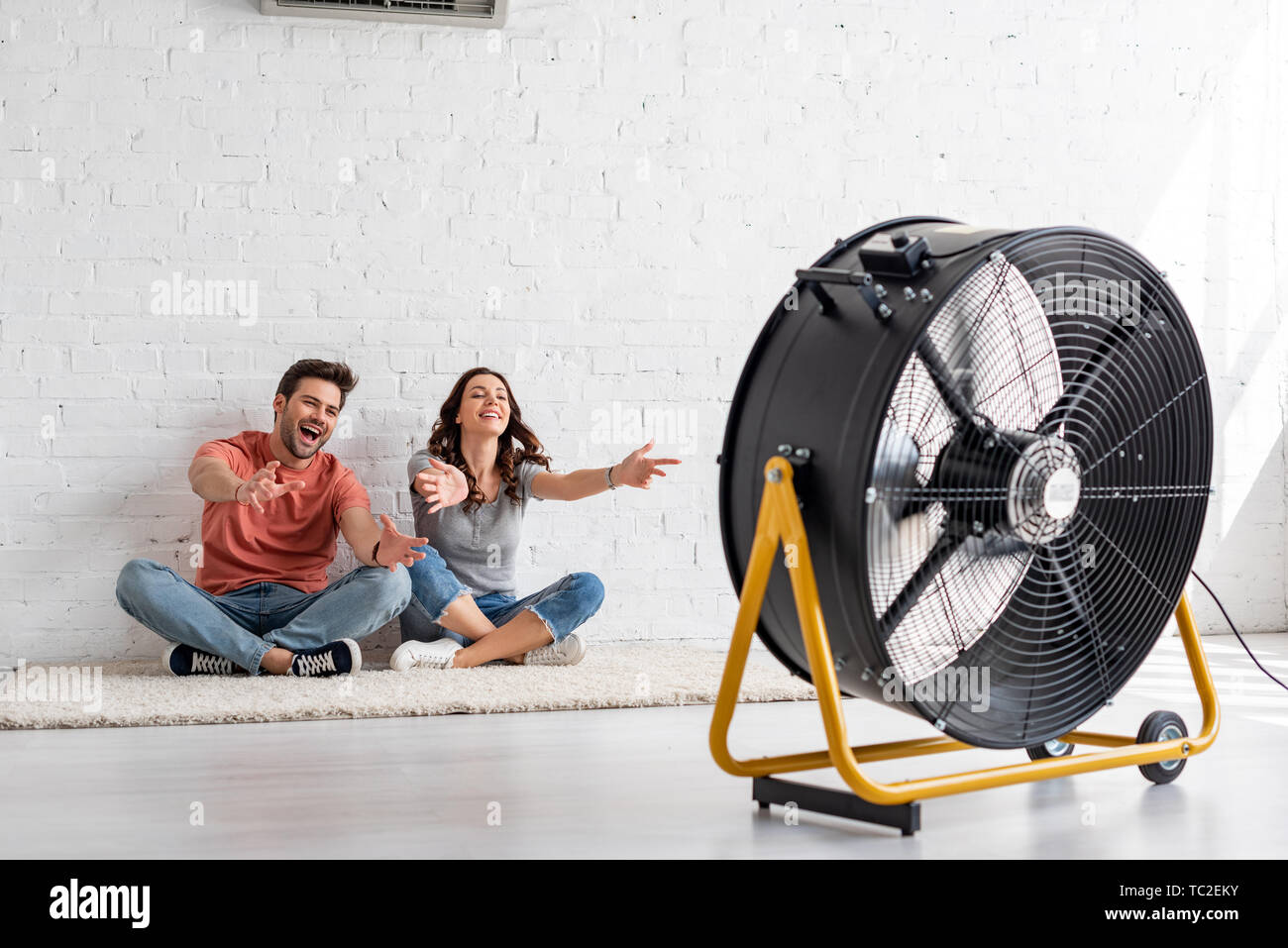 Woman sitting in front of an electric fan hi-res stock photography and ...