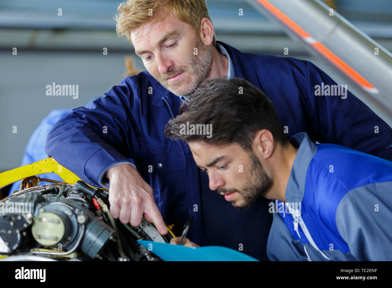 apprentice taking notes of engine parts Stock Photo - Alamy