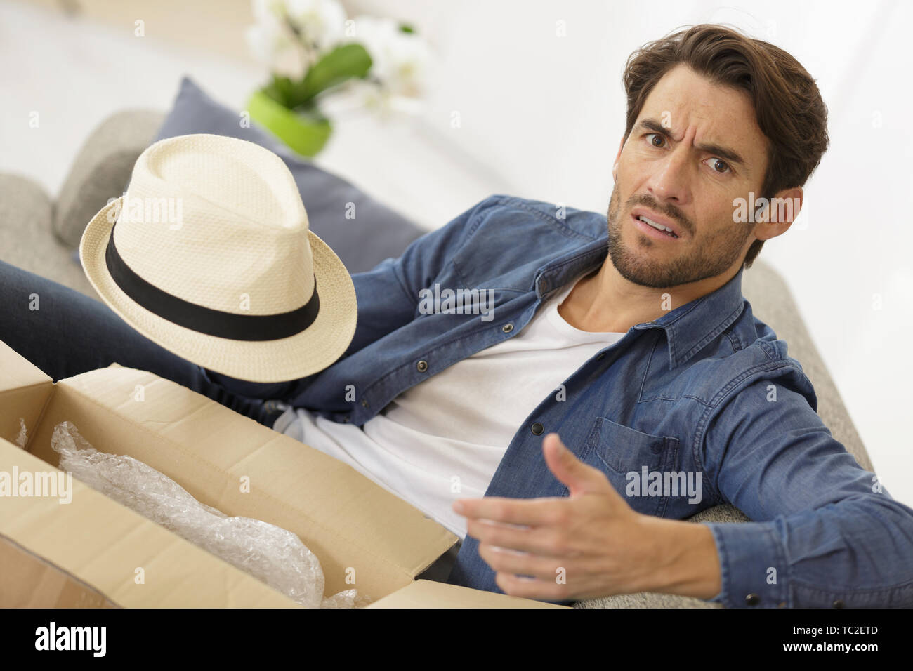 portrait of displease birthday guy holding opened box Stock Photo - Alamy