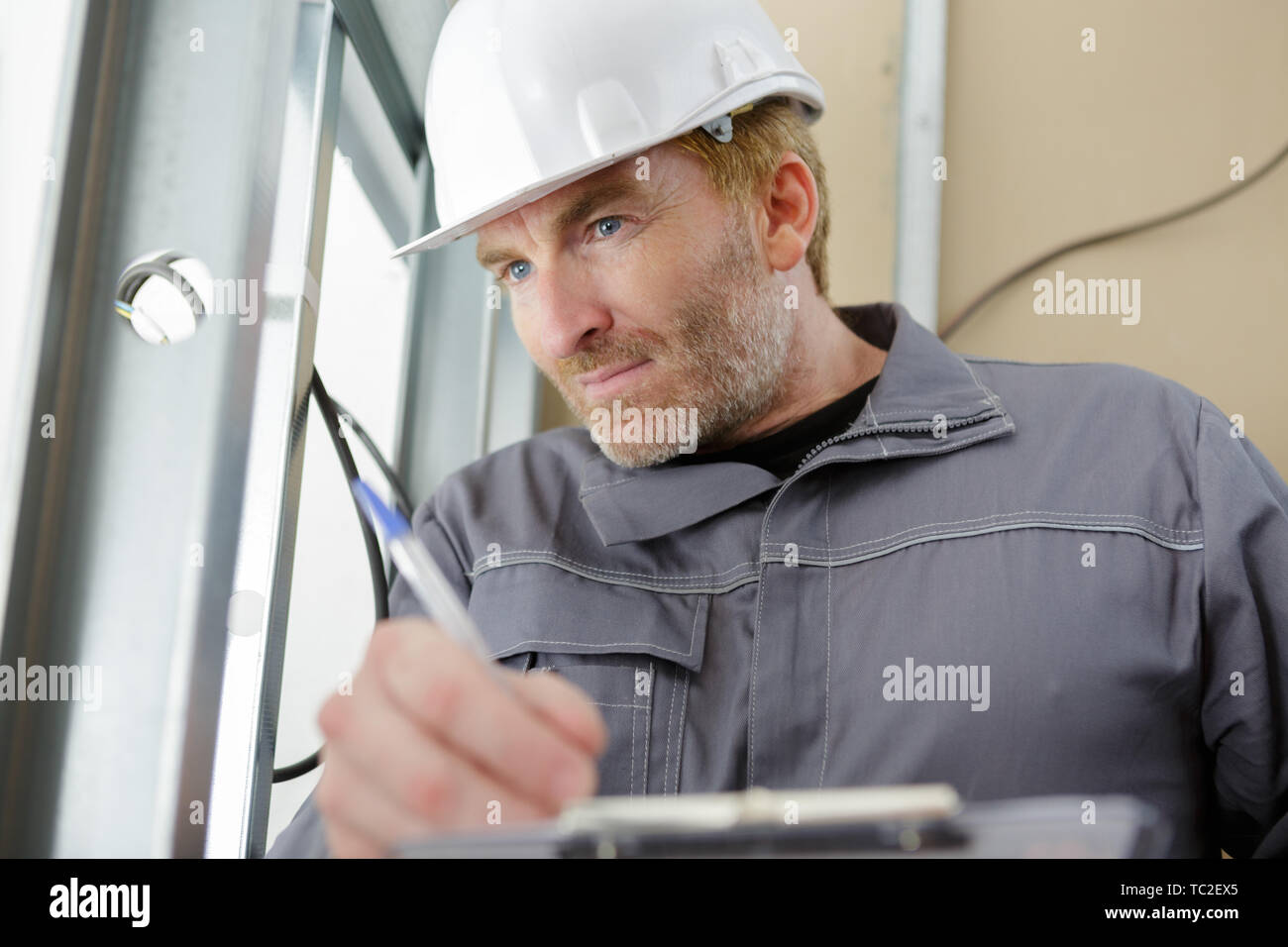construction worker writing on clipboard Stock Photo - Alamy