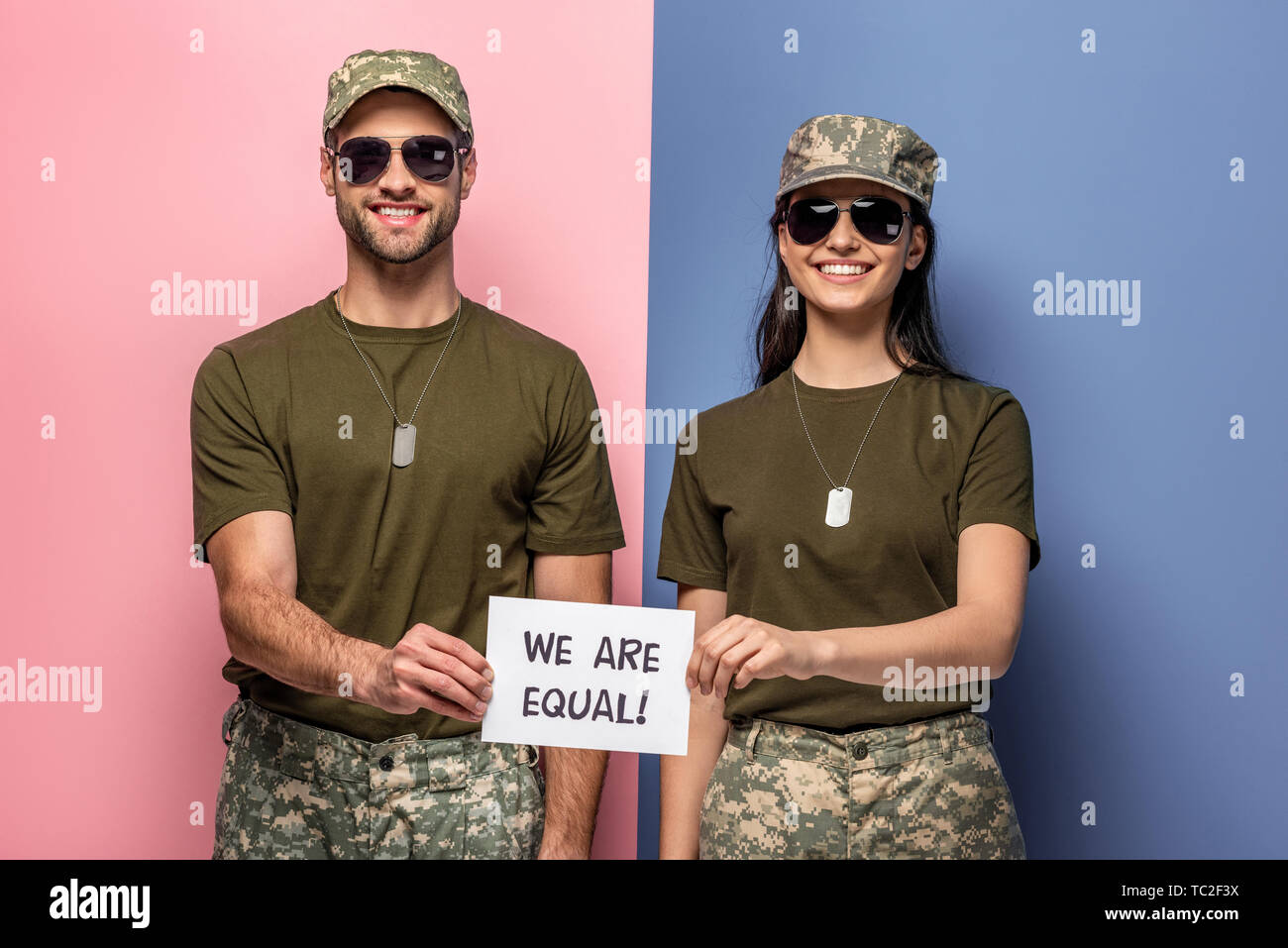 happy man and woman in military uniform holding paper with we are equal ...