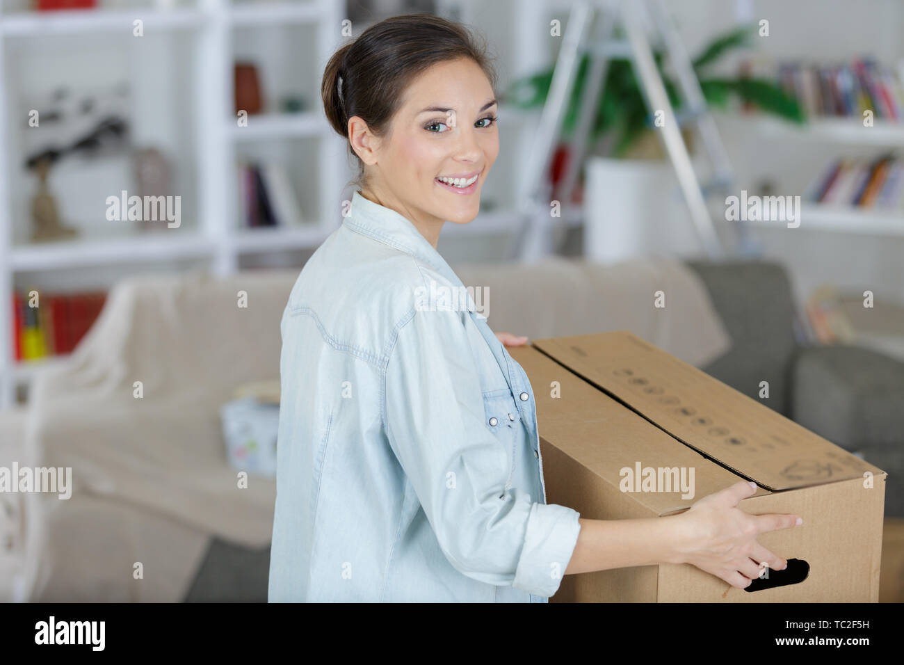 happy young woman moving to new home Stock Photo - Alamy
