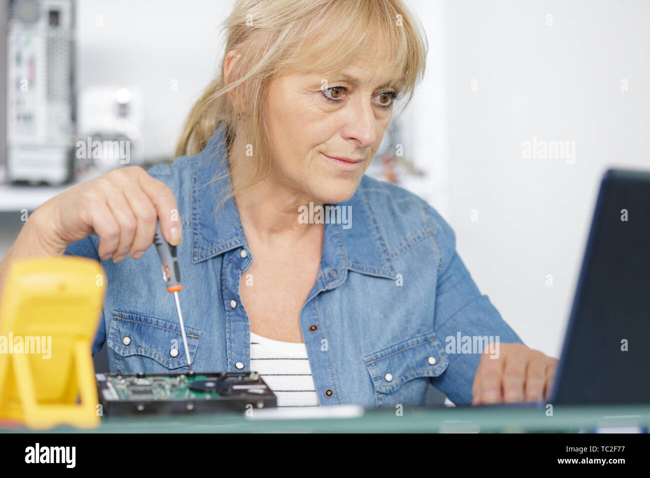 mature woman trying to fix a computer Stock Photo - Alamy