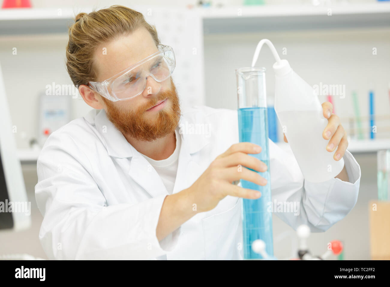 handsome lab worker mixing liquids Stock Photo - Alamy