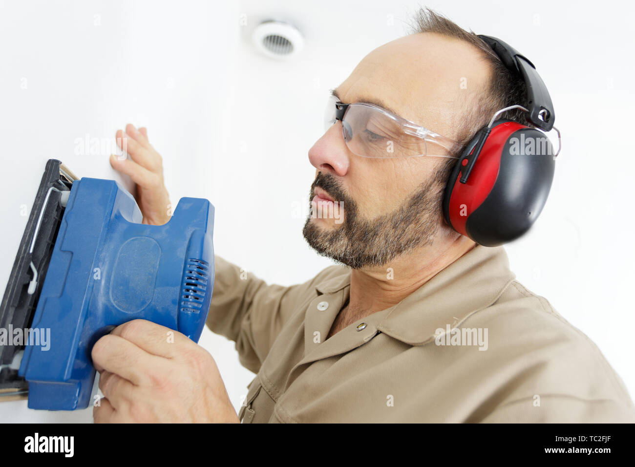 man sanding the wall Stock Photo - Alamy