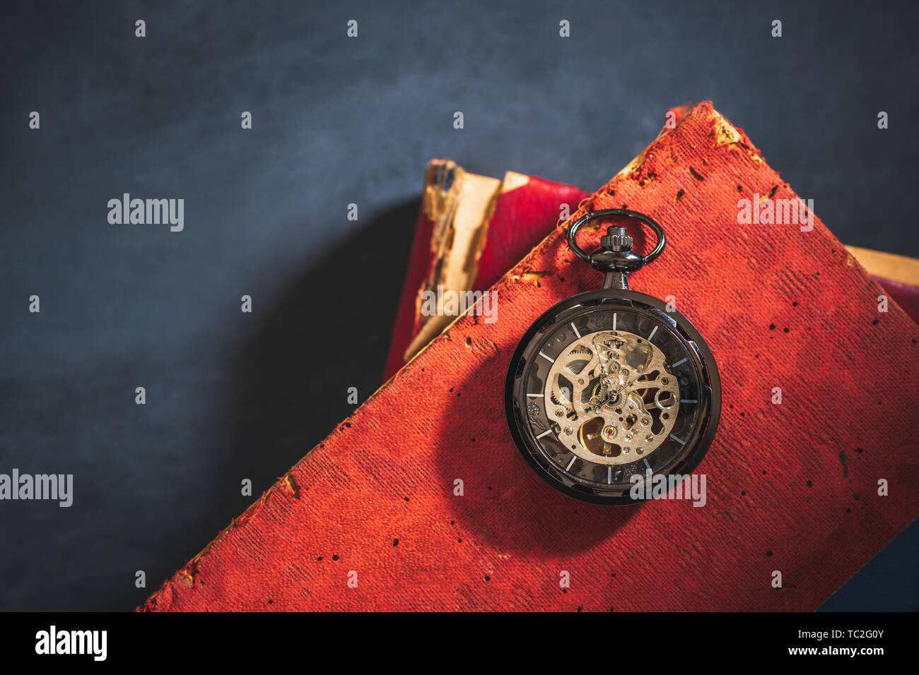 Pocket watch and old book on cement floor. Top view and copy space for ...