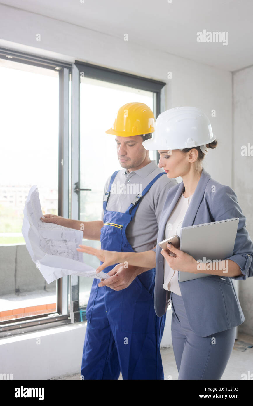 Construction worker and architect looking at plan on site Stock Photo ...