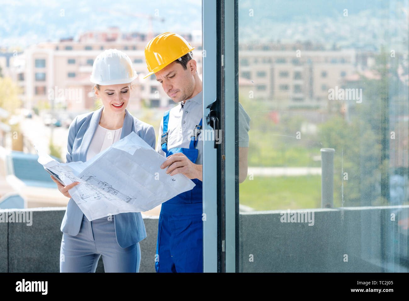 Principal and builder reading blueprints on construction site Stock ...