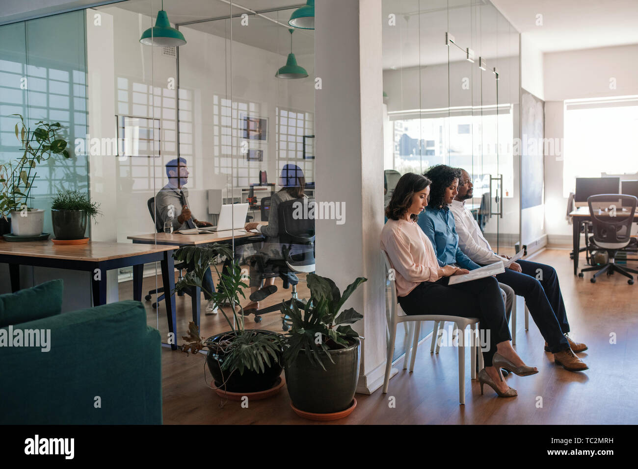 Manager conducting interviews with a group of applicants at work Stock ...