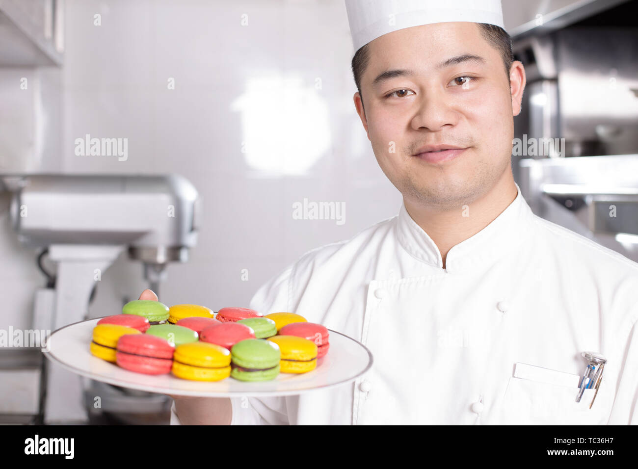 young chinese man chelf making food in modern kitchen Stock Photo - Alamy