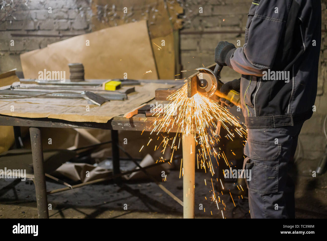 Blacksmith sawing metal with hand circular saw Stock Photo - Alamy