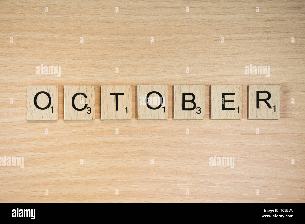The word October, spelt out using wooden tiles on a wood effect ...
