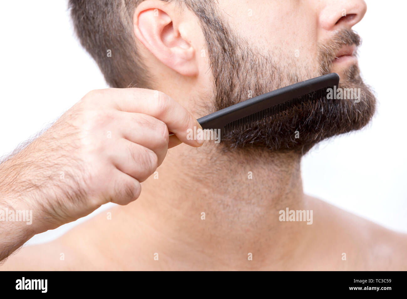 Man combing his beard Stock Photo - Alamy