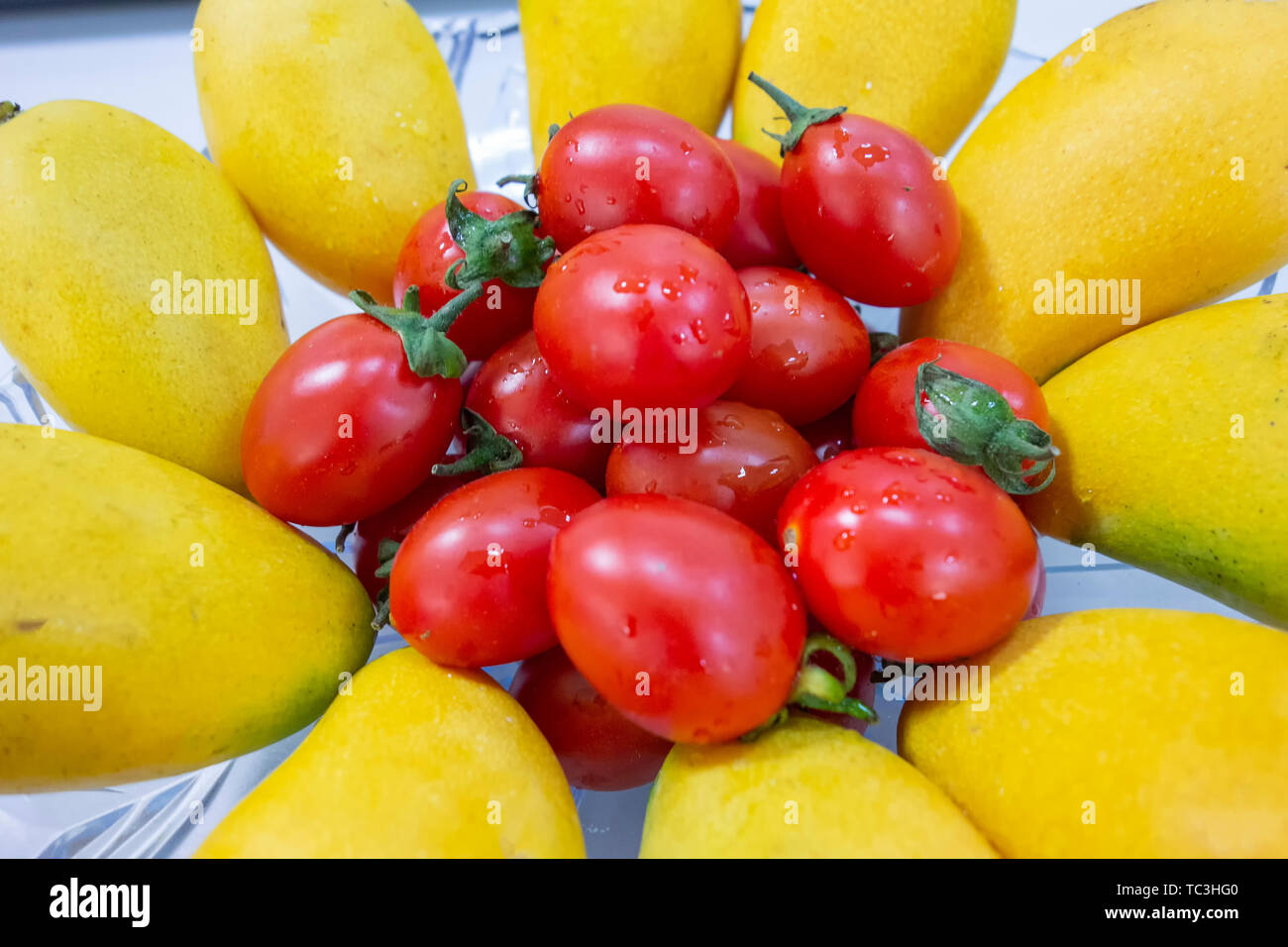 Mango and small tomatoes Stock Photo - Alamy