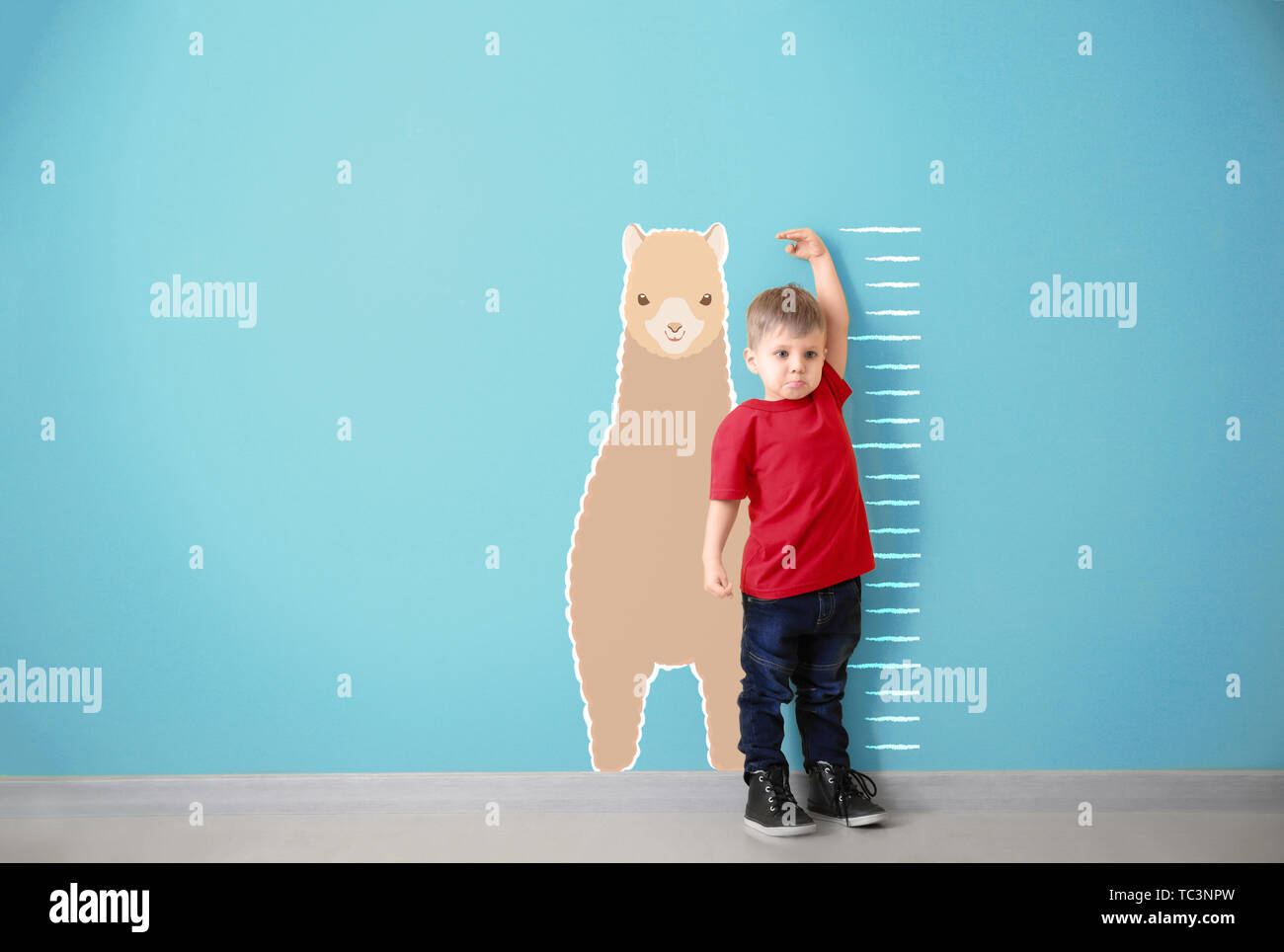 Little boy measuring height near color wall Stock Photo - Alamy