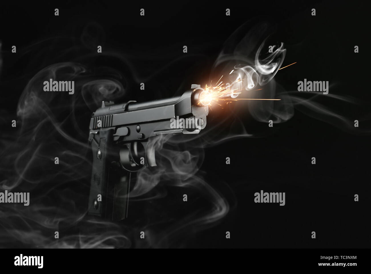 Firing gun on dark background Stock Photo - Alamy
