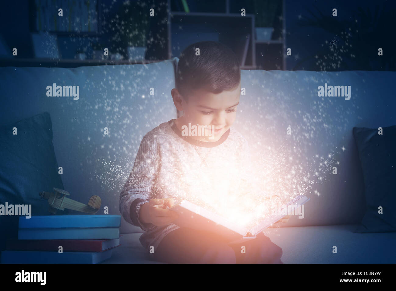 Cute little boy reading magic book at home Stock Photo - Alamy