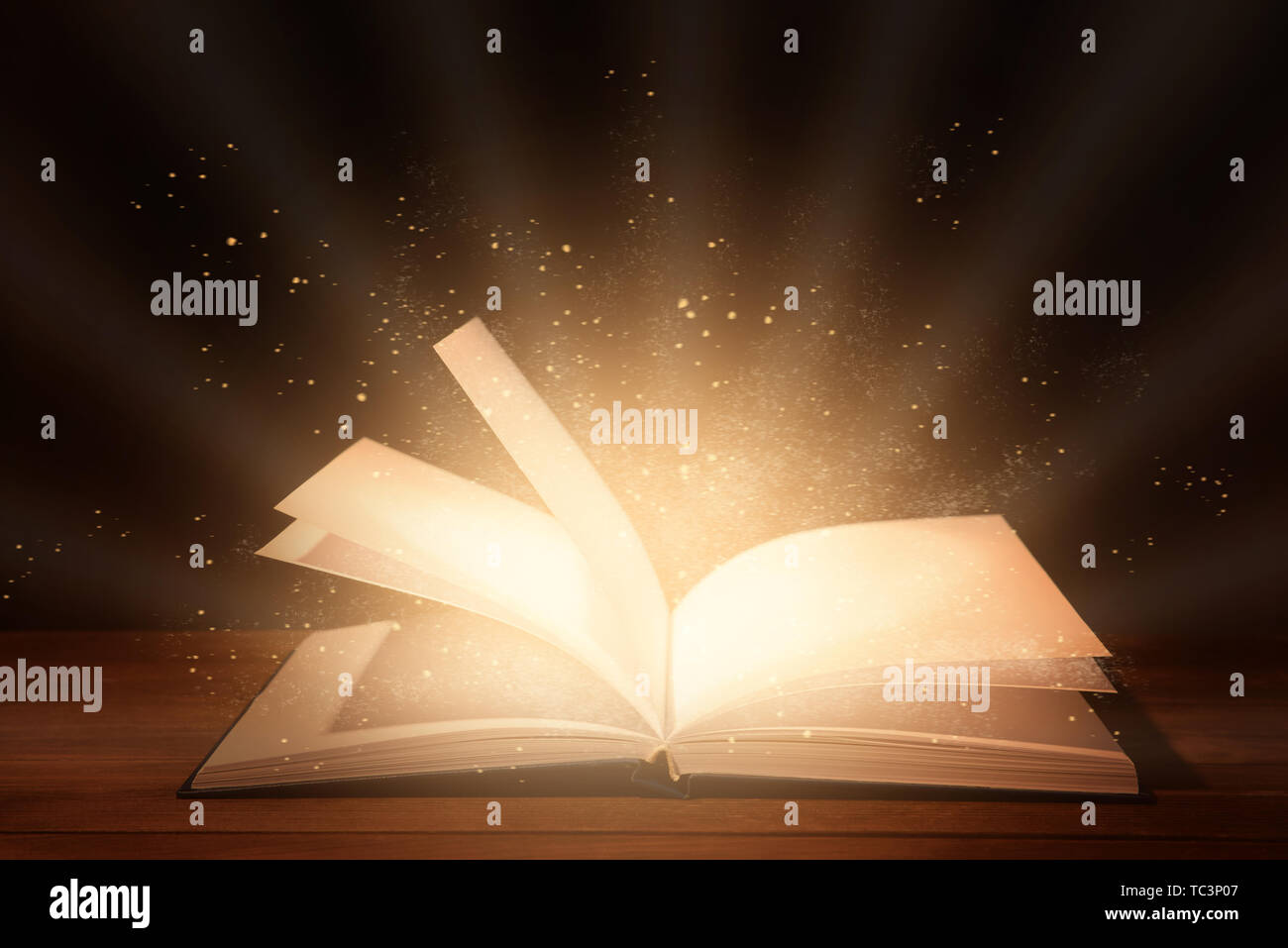 Open magic book on table against dark background Stock Photo - Alamy