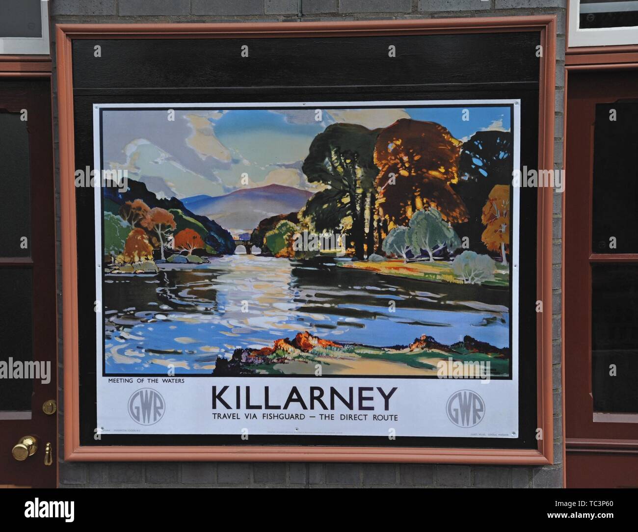A vintage GWR railway advertising sign with a painting of Killarny at ...