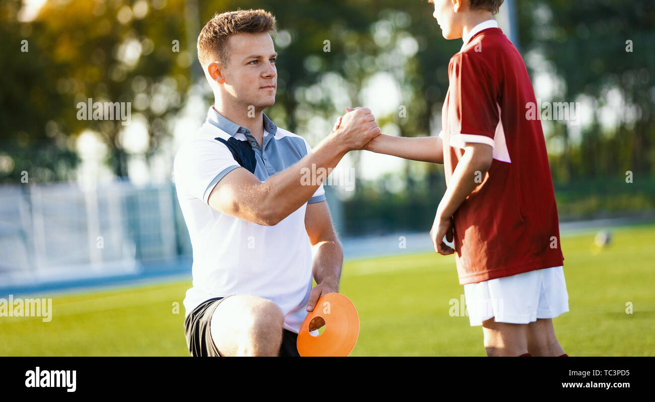 Young Sports Coach Making a High Five with Kids Player. Junior Soccer ...