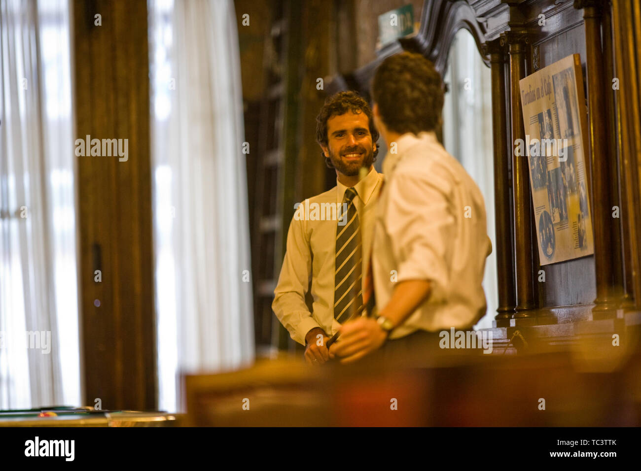 Portrait of a young businessman listening to a male colleague while in ...