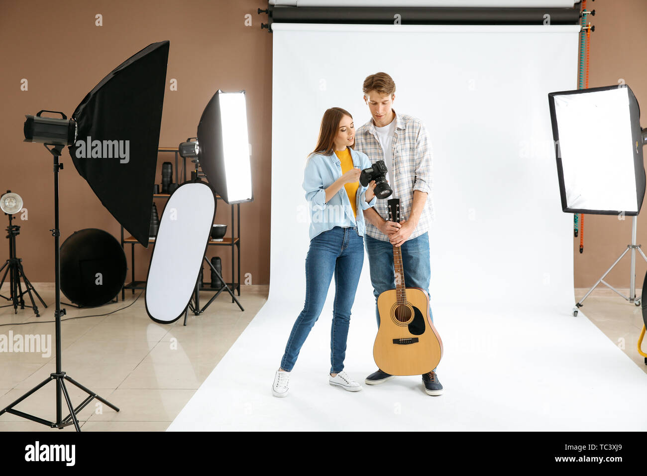 Professional photographer showing pictures to model in studio Stock ...