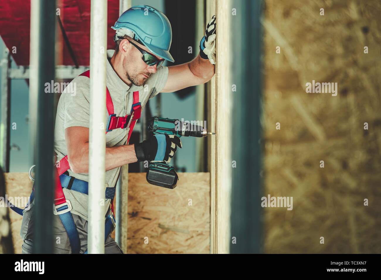Construction At Height Job Caucasian Contractor Wearing Hard Hat With construction-at-height-job-caucasian-contractor-wearing-hard-hat-with