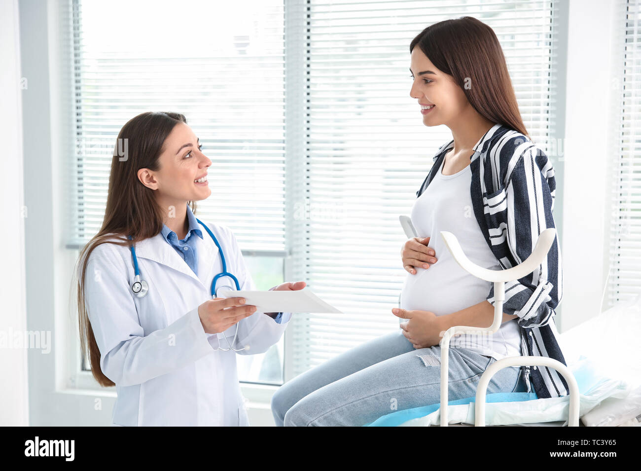 Female gynecologist working with pregnant woman in clinic Stock Photo ...