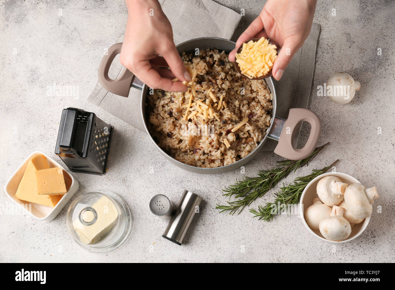 Woman cooking tasty risotto at table Stock Photo - Alamy