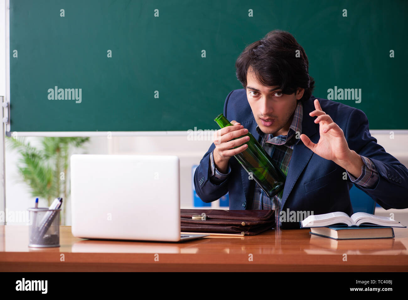 Male teacher drinking in the classroom Stock Photo - Alamy