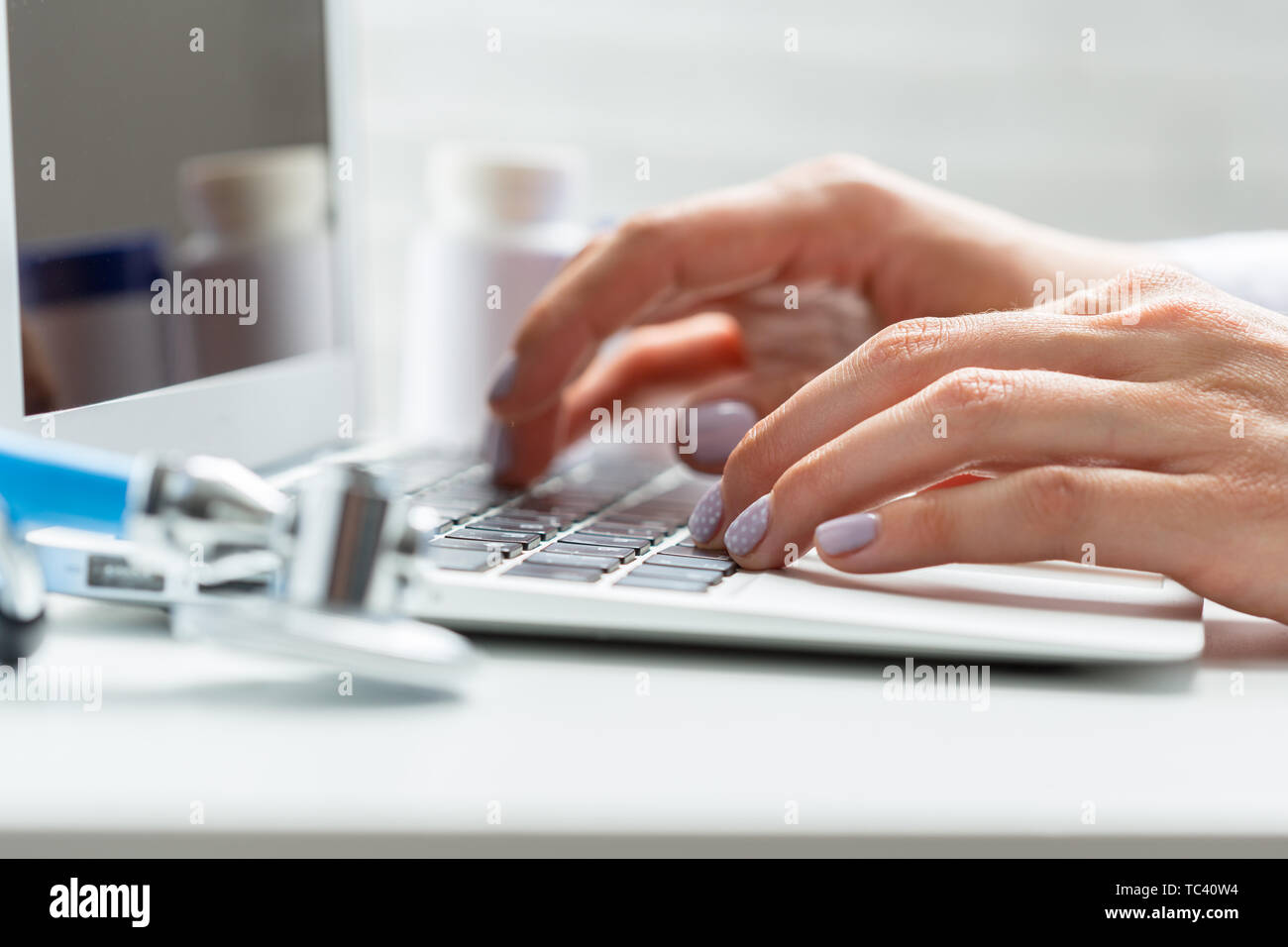 Female doctor is typing in laptop computer Stock Photo - Alamy